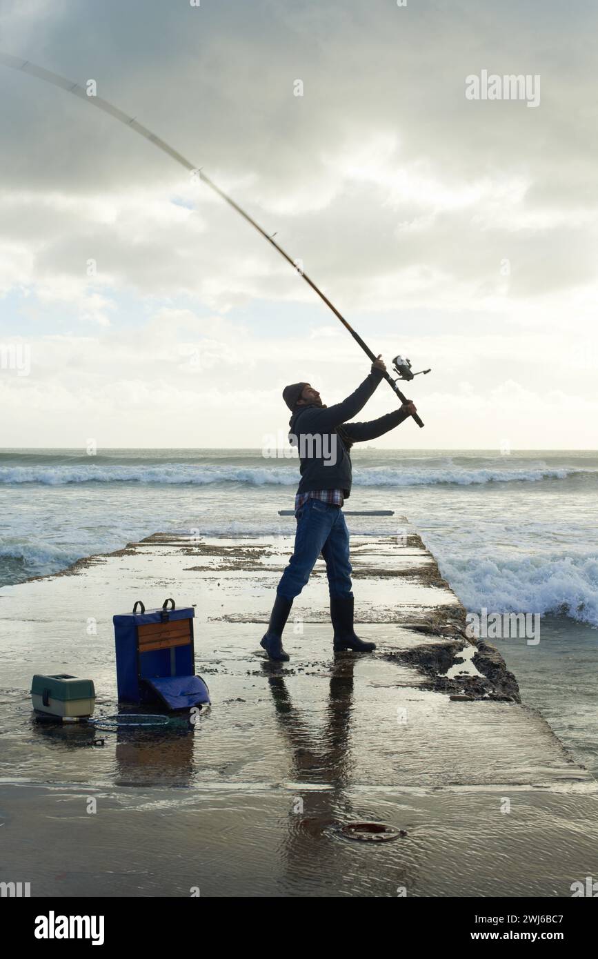 Fishing, fisherman and man on pier by ocean with rod, reel and ...