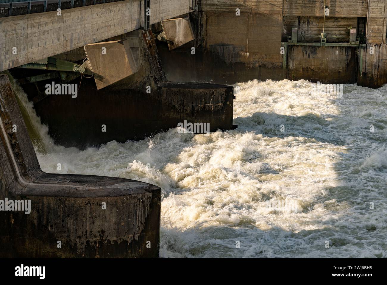 Water shooting through the weir of an electrical power plant, foaming ...