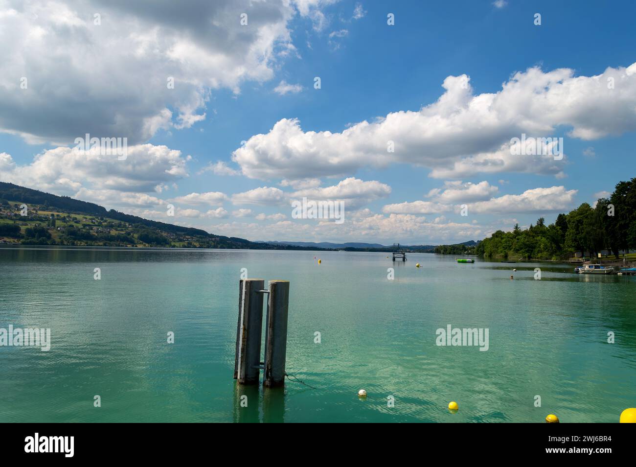 Shot over lake Hallwil in Switzerland on a summer's day with blue sky and white clouds. Green ...