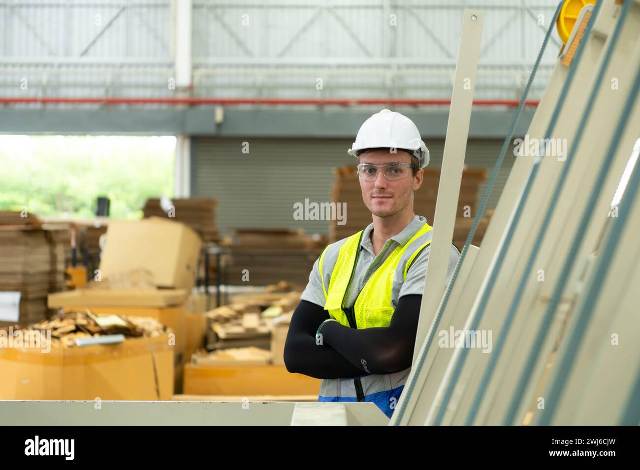 Portrait of confident male warehouse worker standing with arms crossed ...