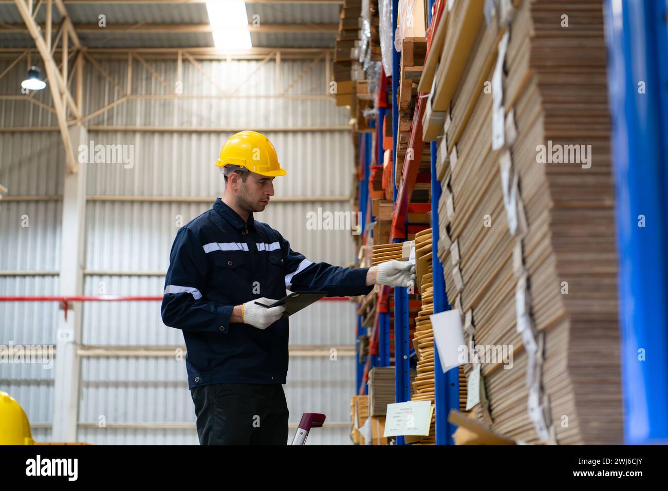 Young male warehouse worker checking stock in a warehouse. This is a ...