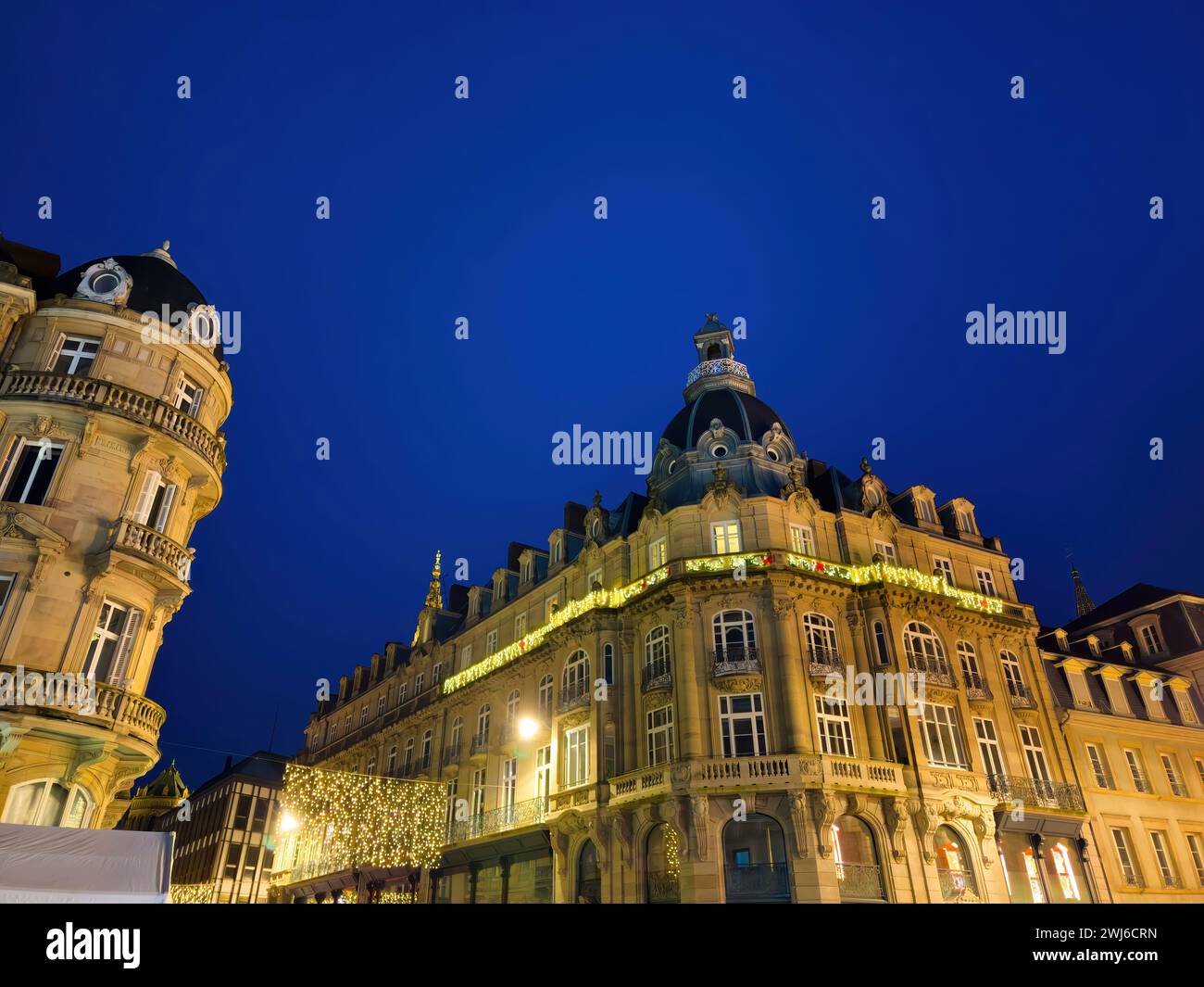 A very tall Hausmannian building with Christmas decorations displayed ...