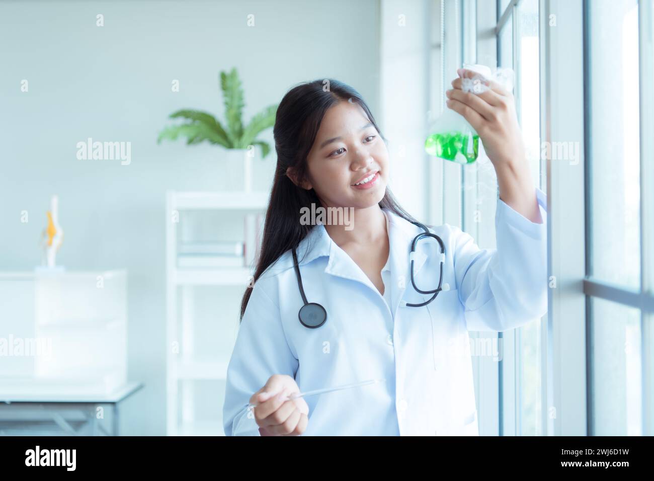 In the science classroom, an Asian child scientist experimenting with ...