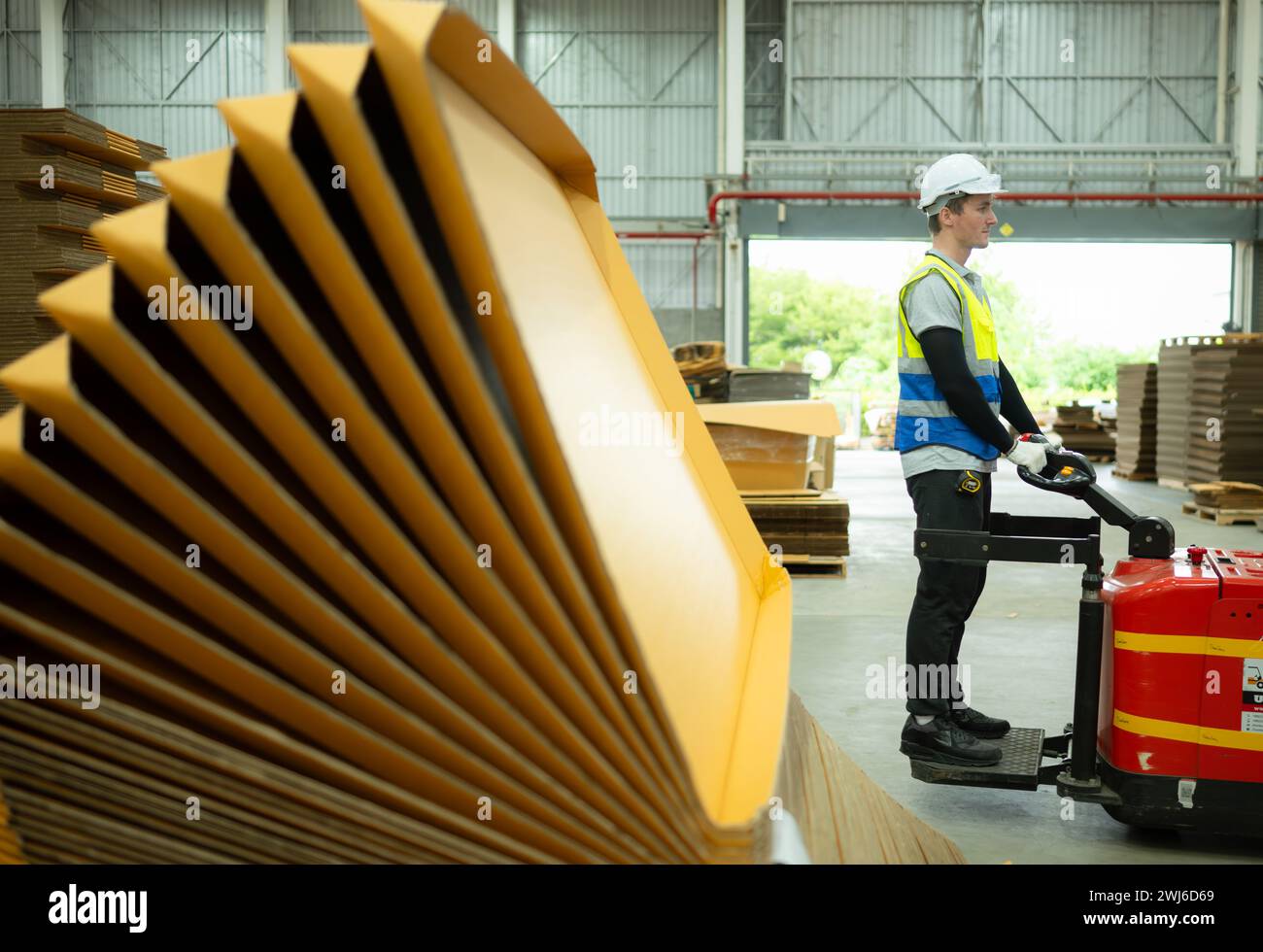 Young female warehouse worker checking and counting cardboard boxes in ...