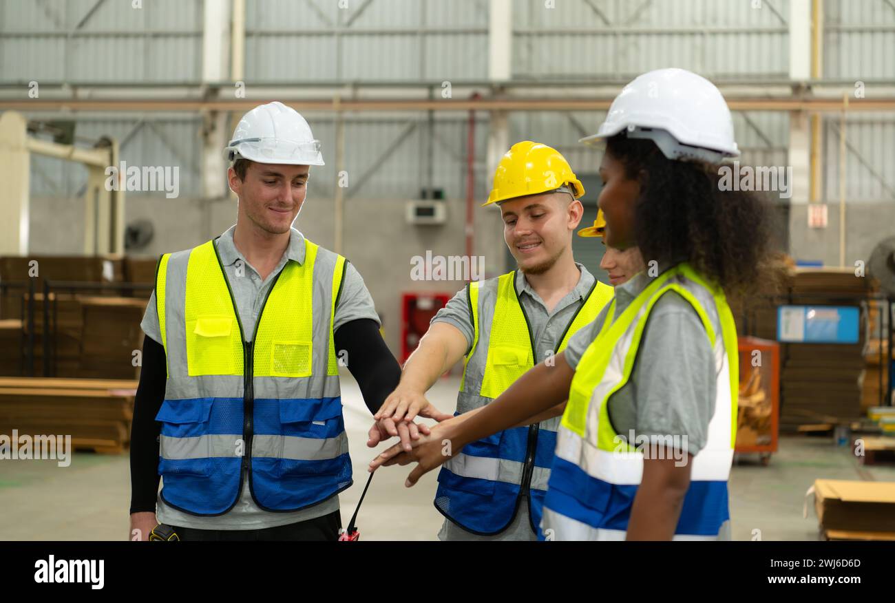 Front view of a diverse group of warehouse workers holding hands to ...