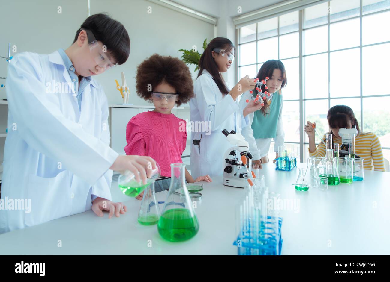 In the science classroom, an Asian child scientist experimenting with ...