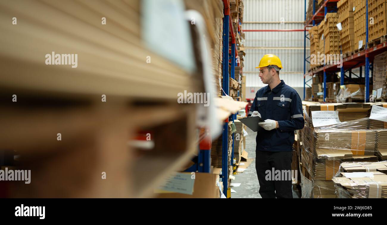 Young male warehouse worker checking stock in a warehouse. This is a ...