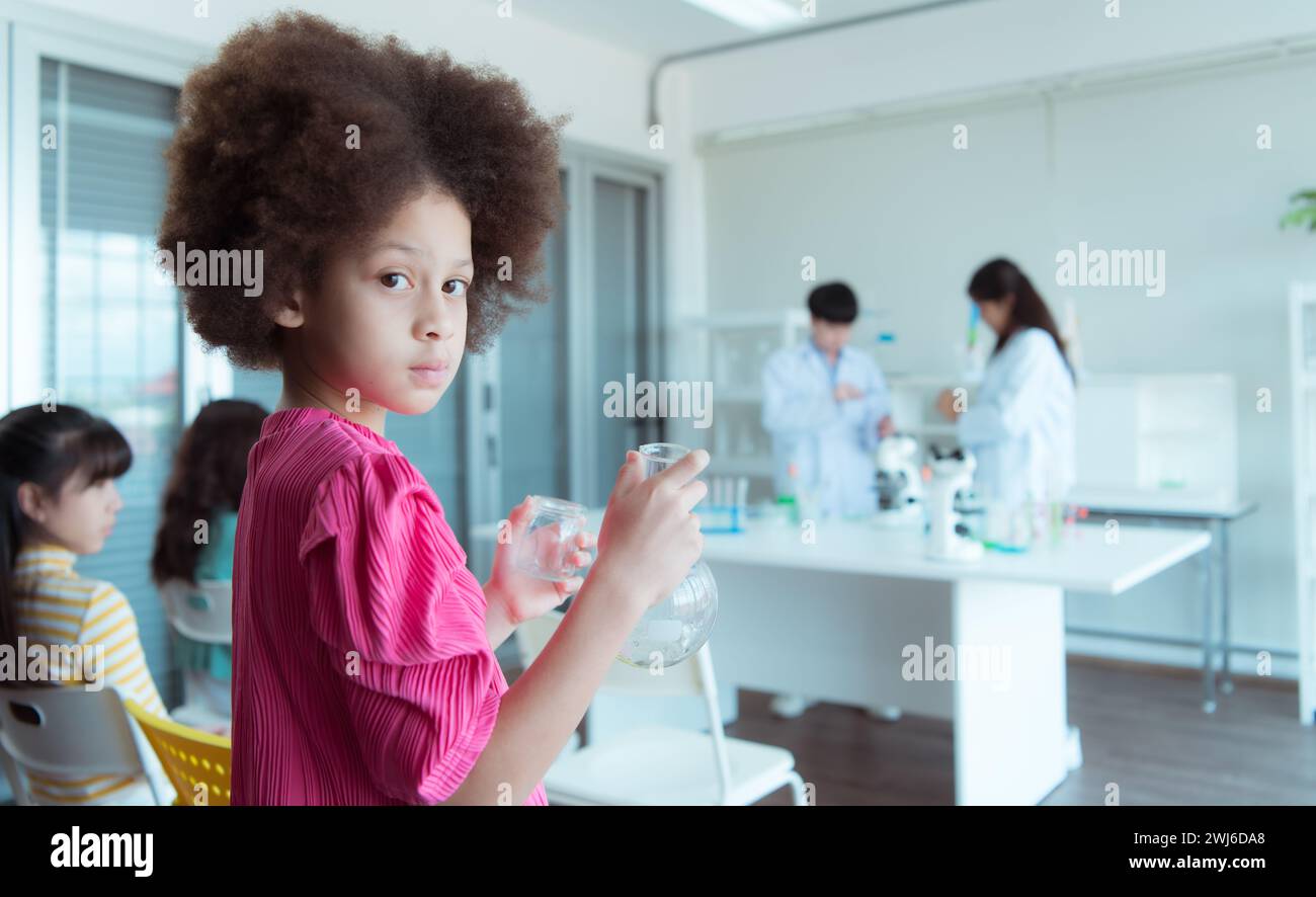 In the science classroom, an Asian child scientist experimenting with ...