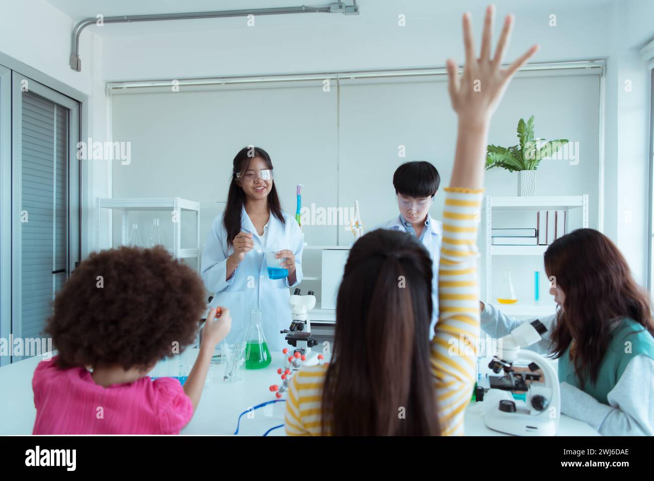 In the science classroom, an Asian child scientist experimenting with ...