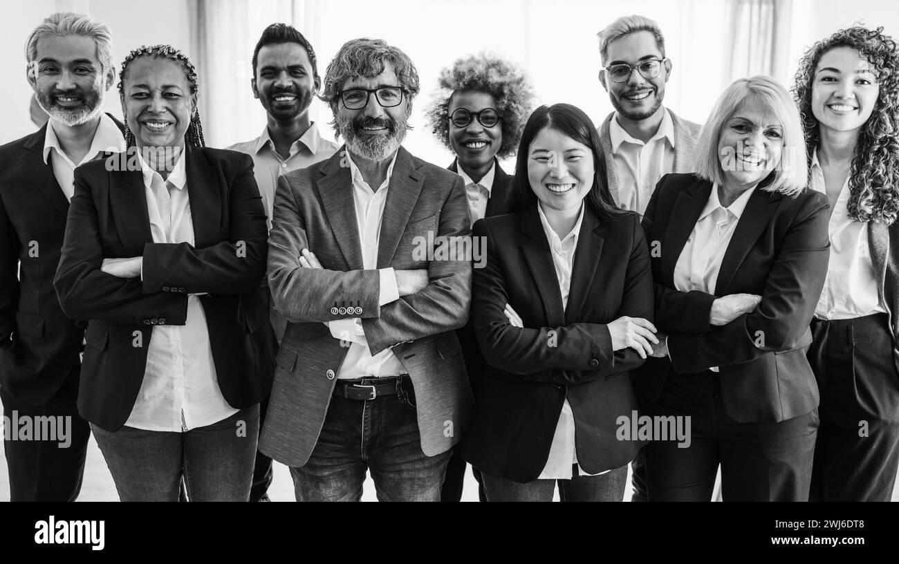 Multi generational workers smiling in front of camera inside business ...