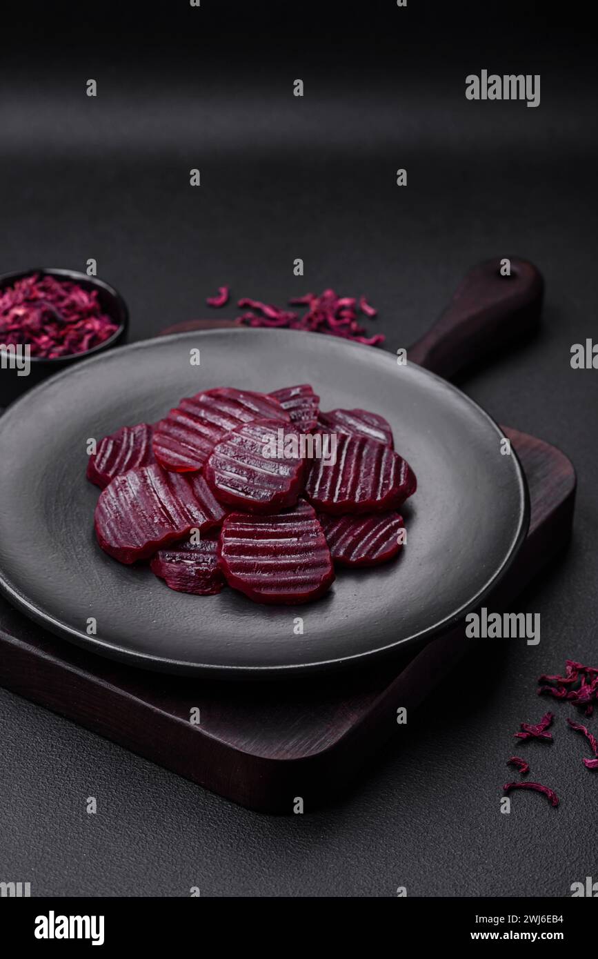 Delicious healthy boiled ruby colored beets sliced on a black plate on ...