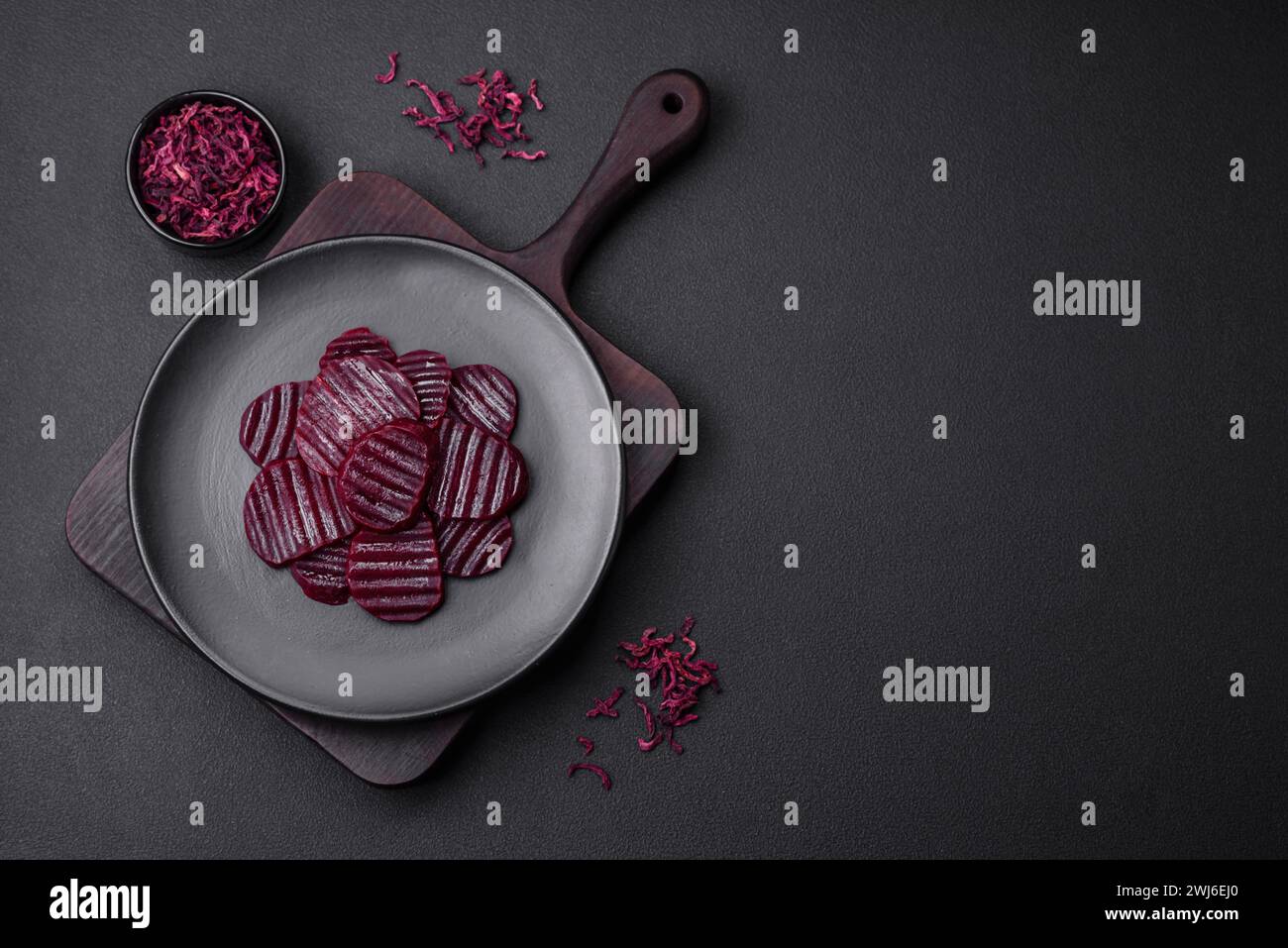 Delicious healthy boiled ruby-colored beets sliced ??on a black plate ...