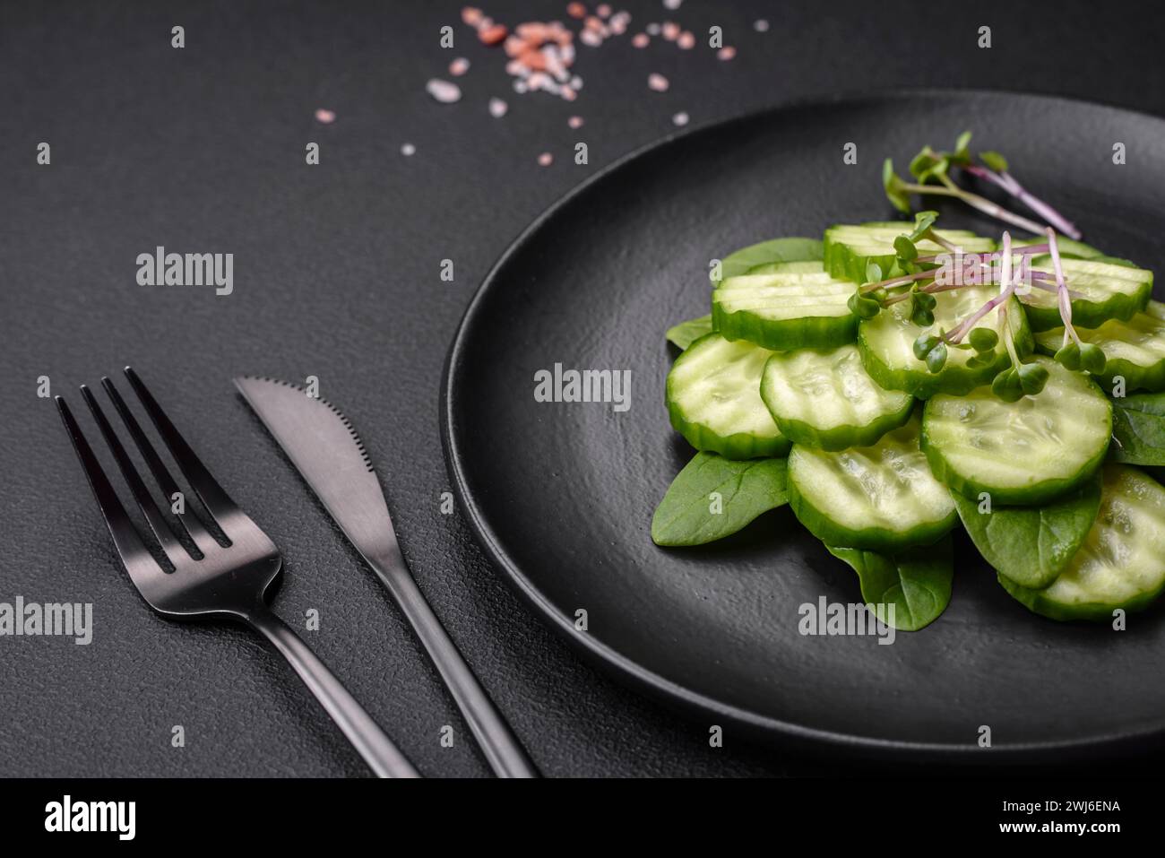 Delicious healthy raw cucumber sliced ??on a black ceramic plate Stock ...