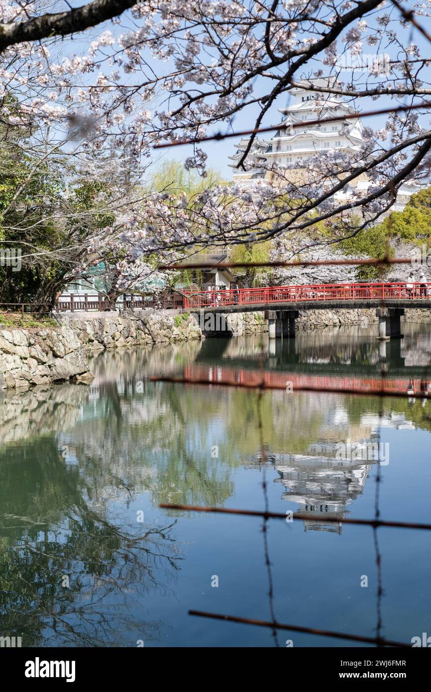 Reflection of Himeji Castle in the moat, viewed through barbed wire ...