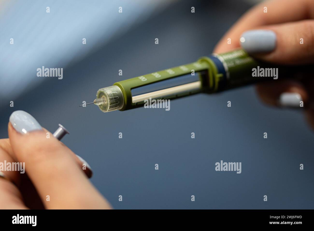 Berlin, Germany. 13th Feb, 2024. A woman holds an insulin pen with an ...