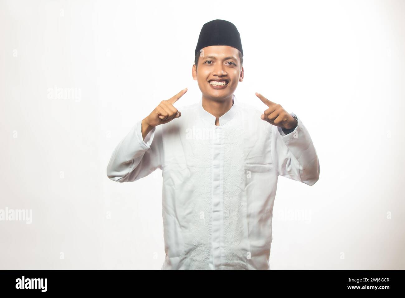 Brown skinned Asian Muslim man smiling facing the camera and both hands ...