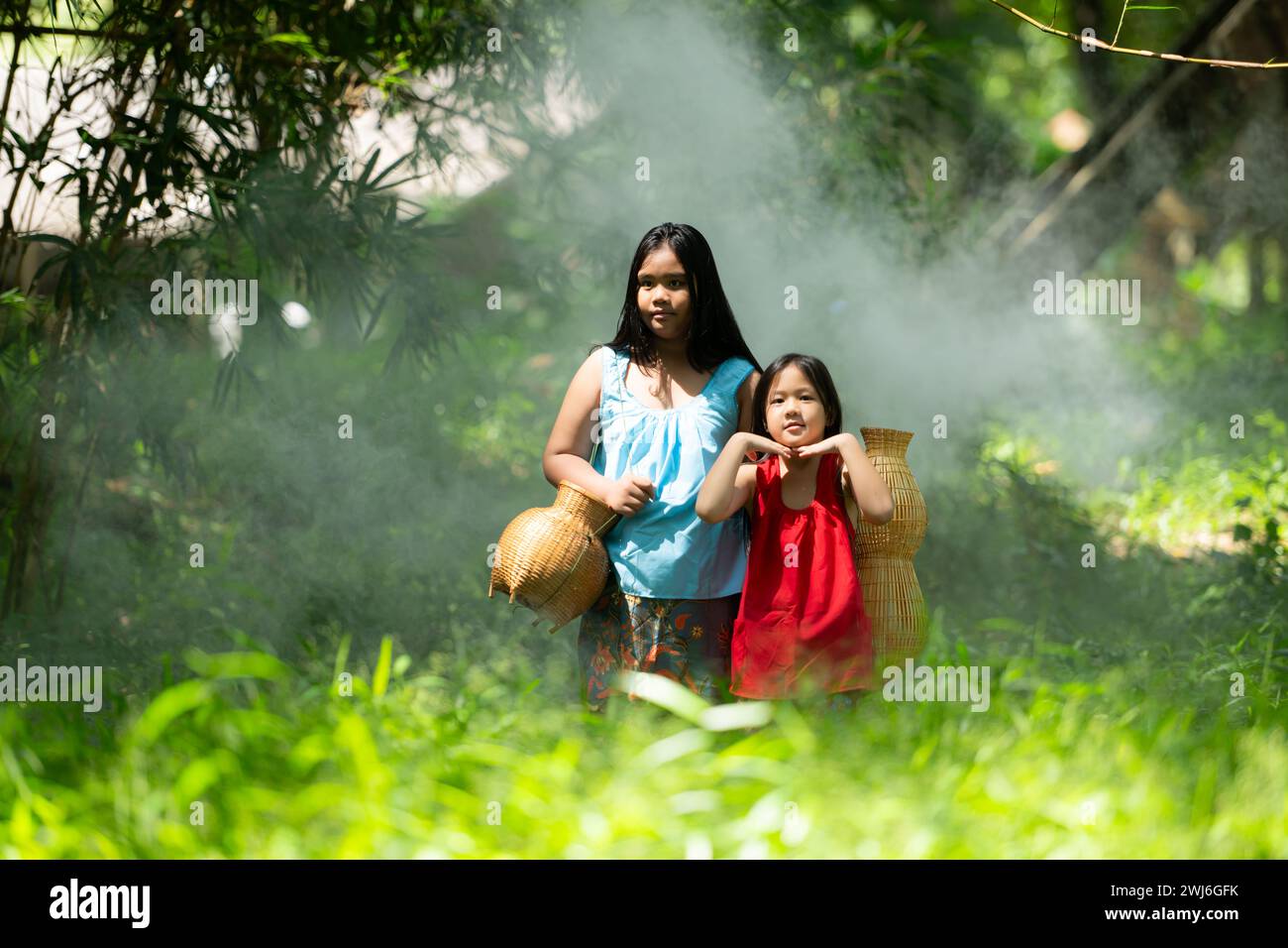 Two girls Asian women with traditional clothing stand in the rainforest ...