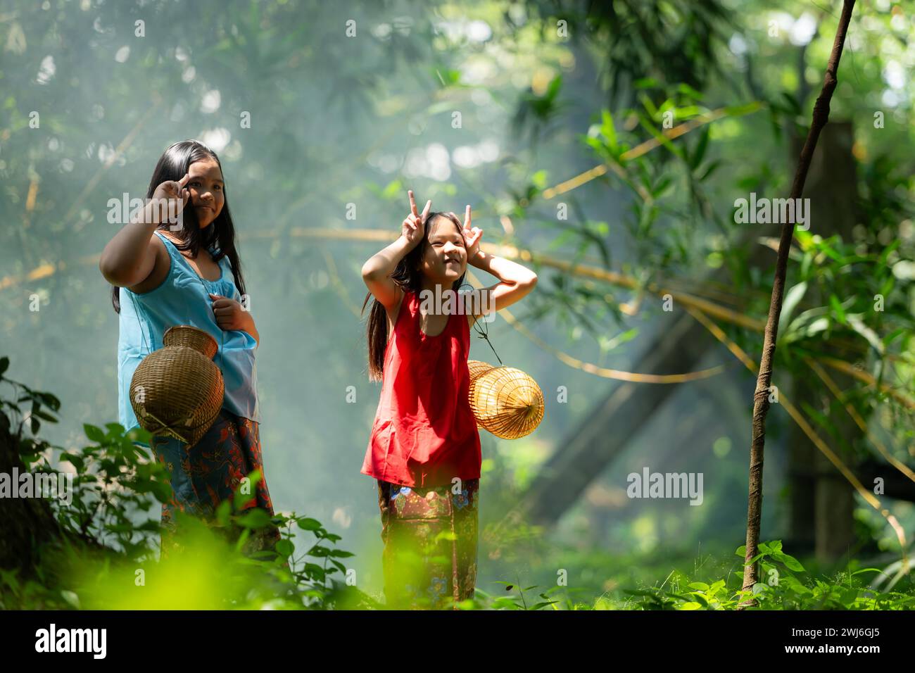 Two girls Asian women with traditional clothing stand in the rainforest ...