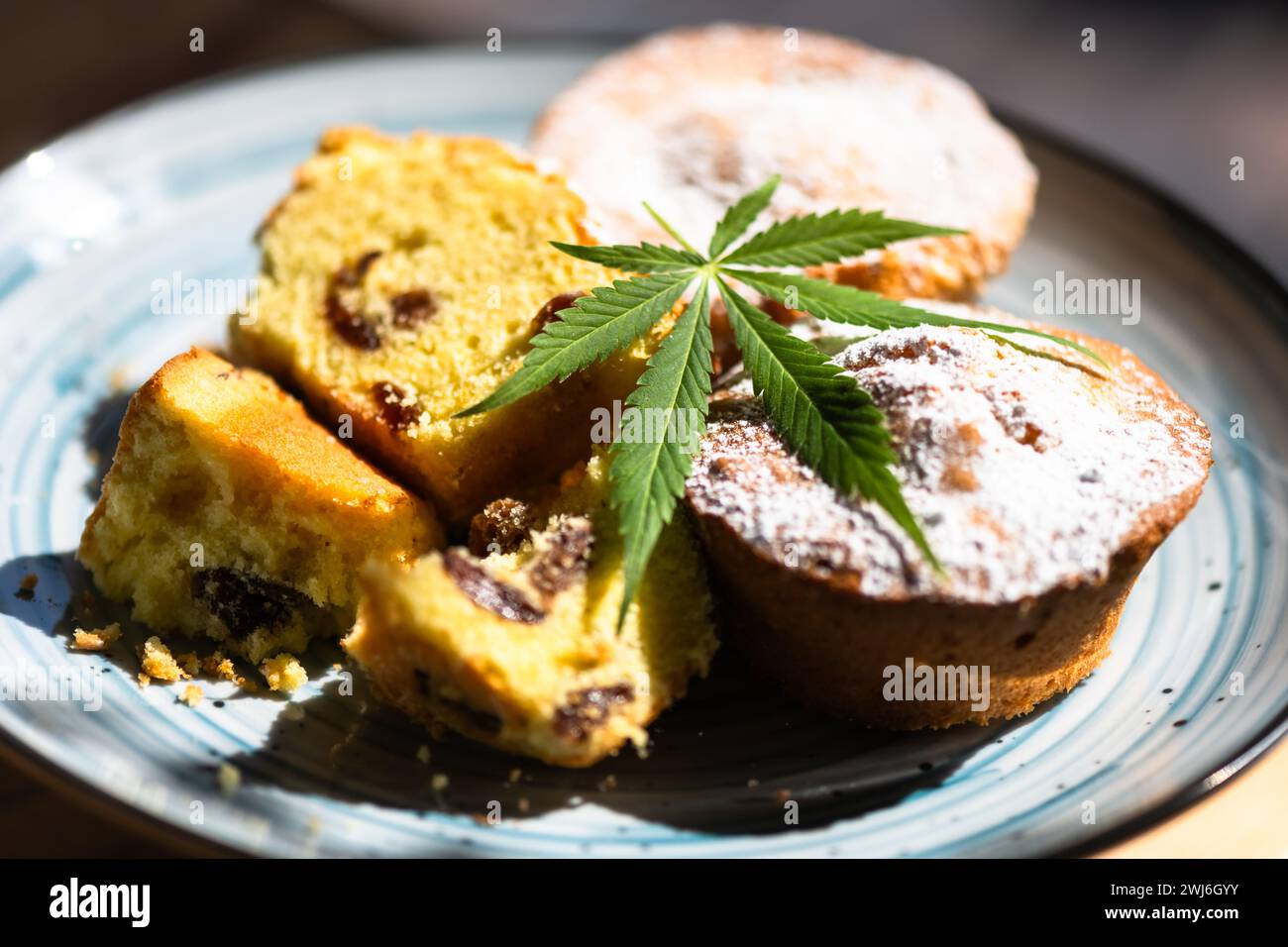 Sweet cupcakes with green cannabis leaf on plate. Dessert cake with ...