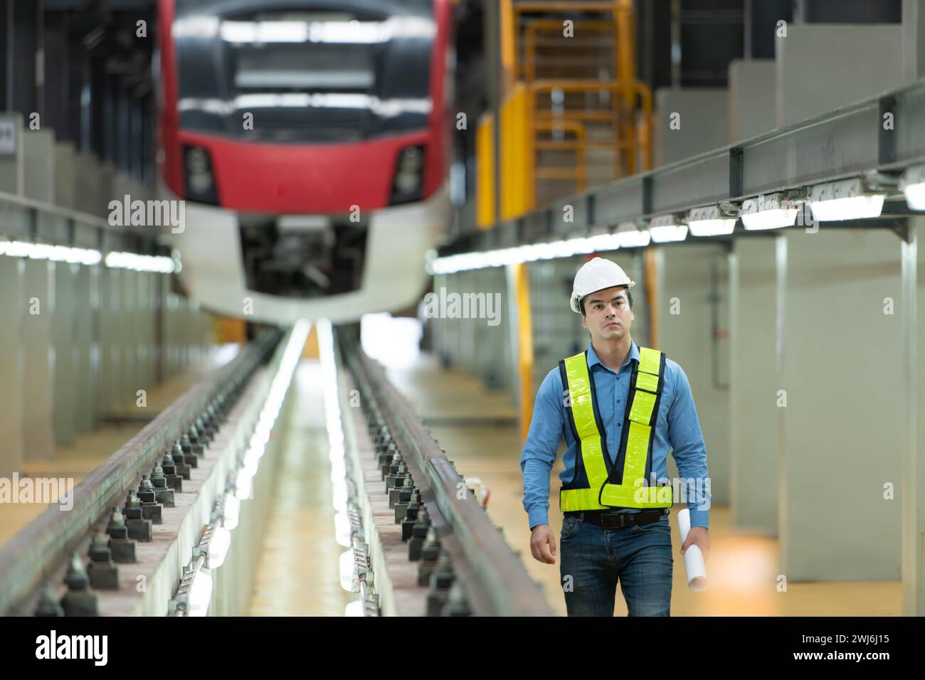 Electric vehicle engineer with blueprint work to Inspect the machinery ...
