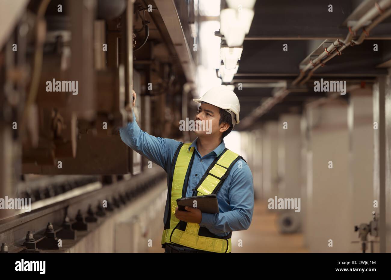 Electric train engineer inspect electric train machinery with tablets ...