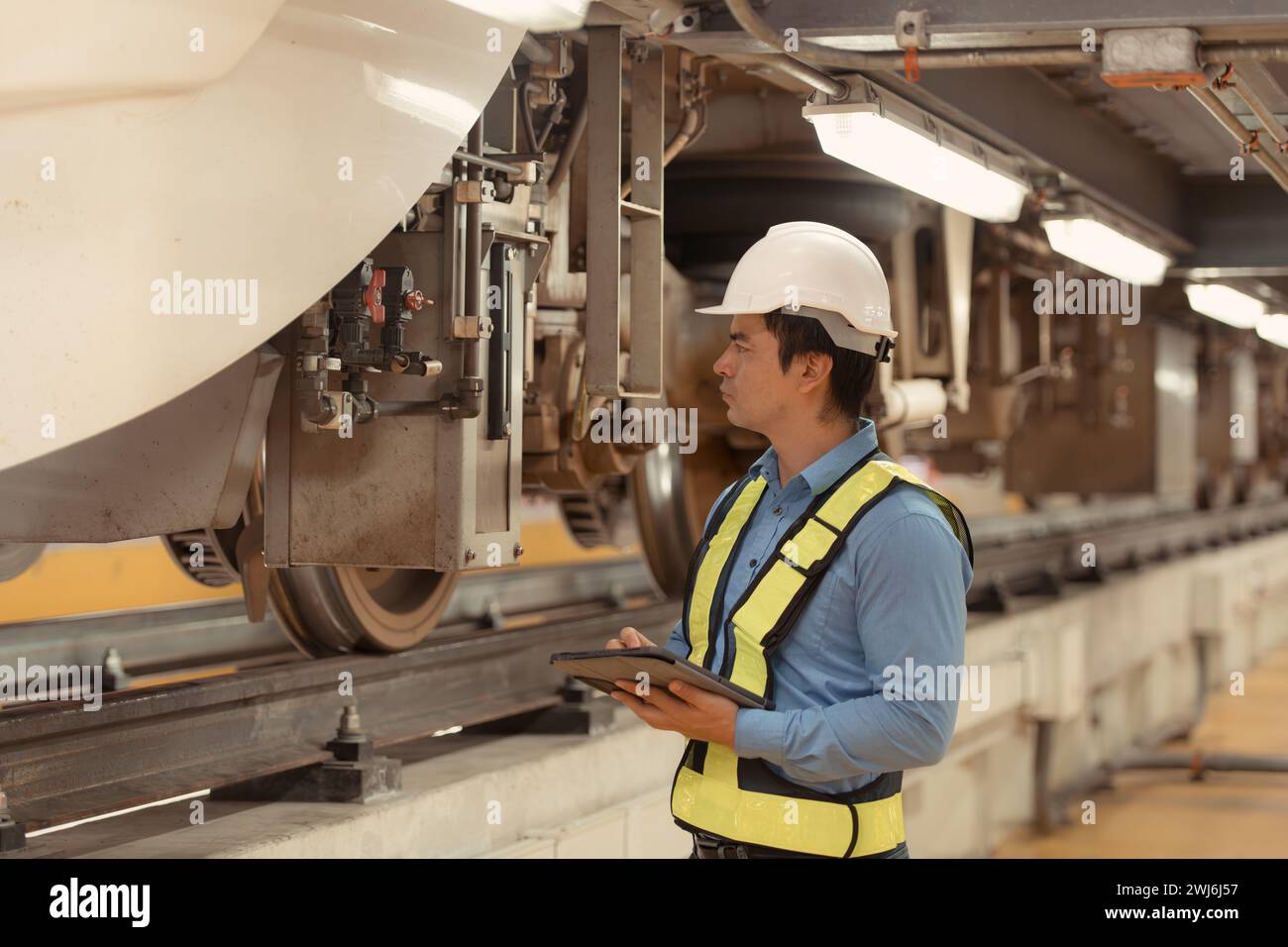 Electric train engineer inspect electric train machinery with tablets ...