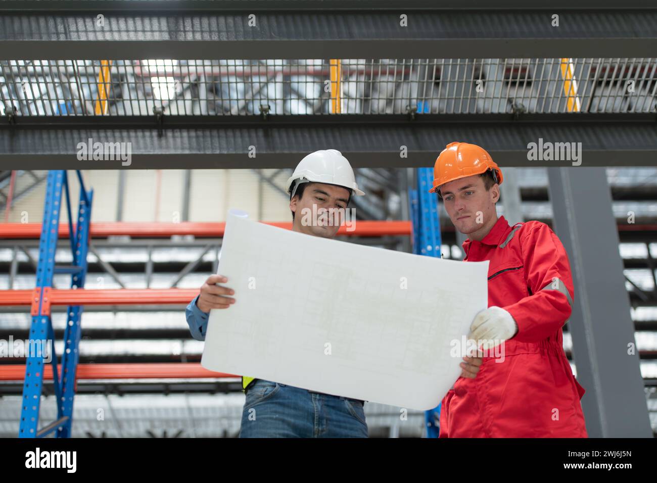 Portrait of two engineer discussing blueprints of electric train ...