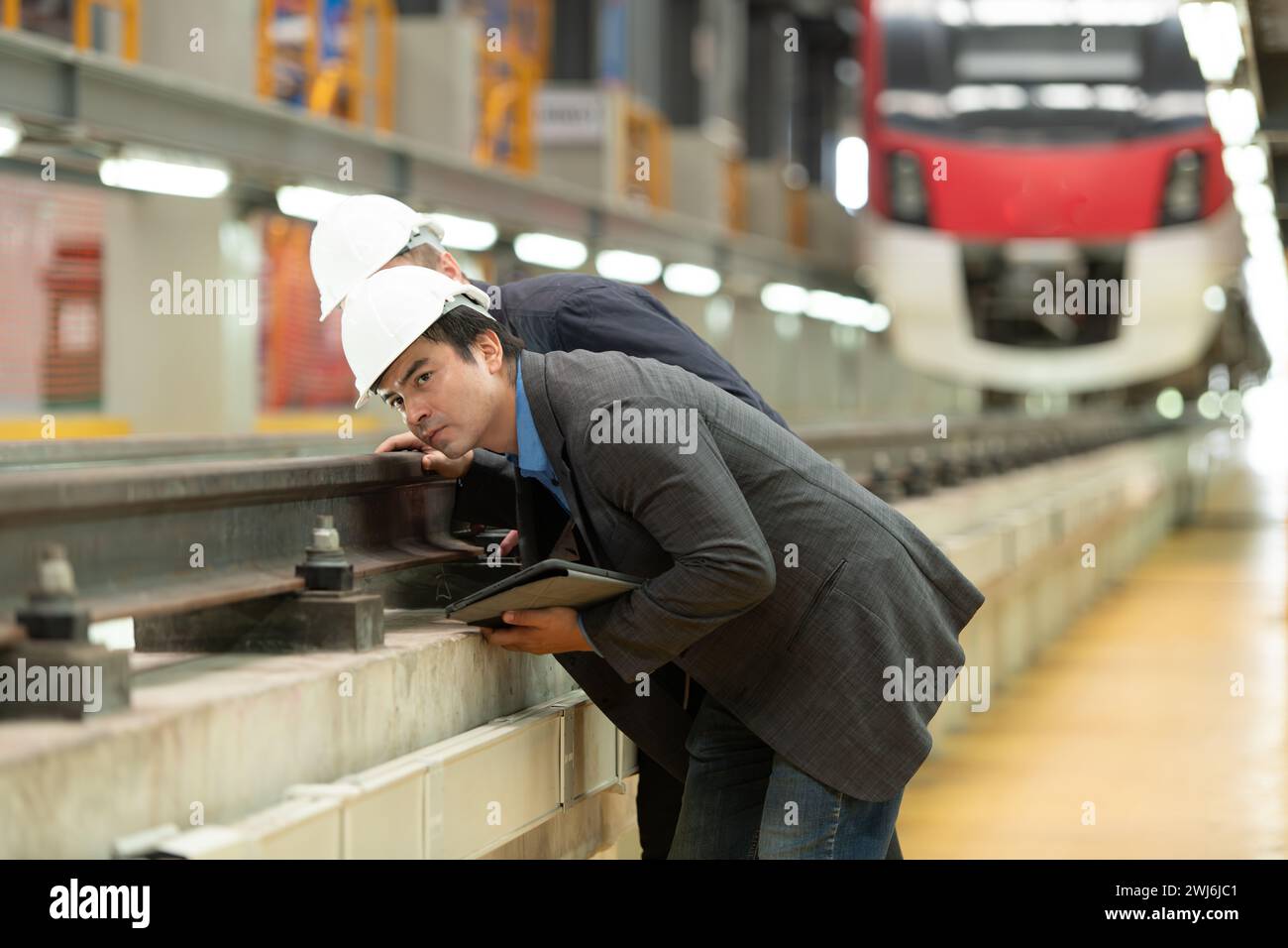 Two businessmen inspect rail work to reserve equipment for use in ...