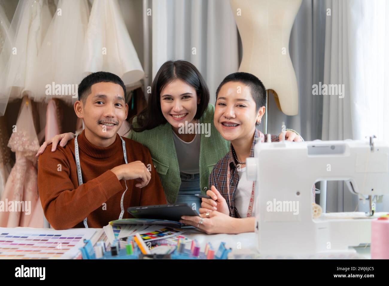 Group of asian fashion designers working with sewing machine in the ...