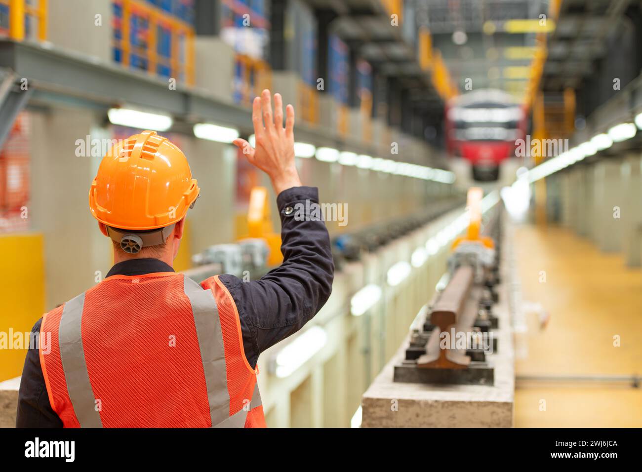 Rear view of electric train industry engineer wearing a safety helmet ...