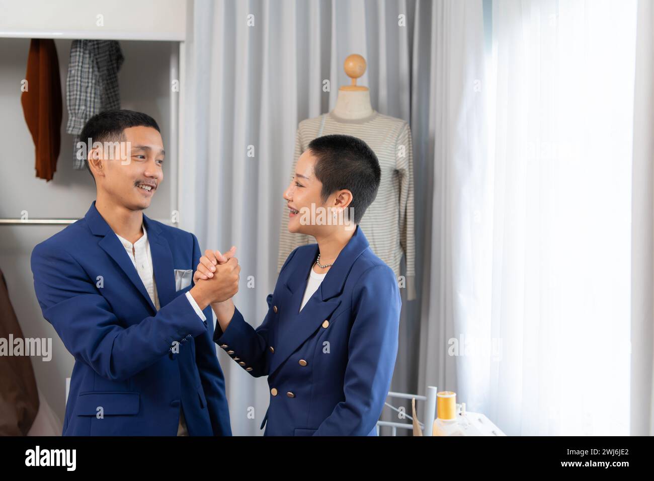 Both of asian fashion designers working with sewing machine in the ...