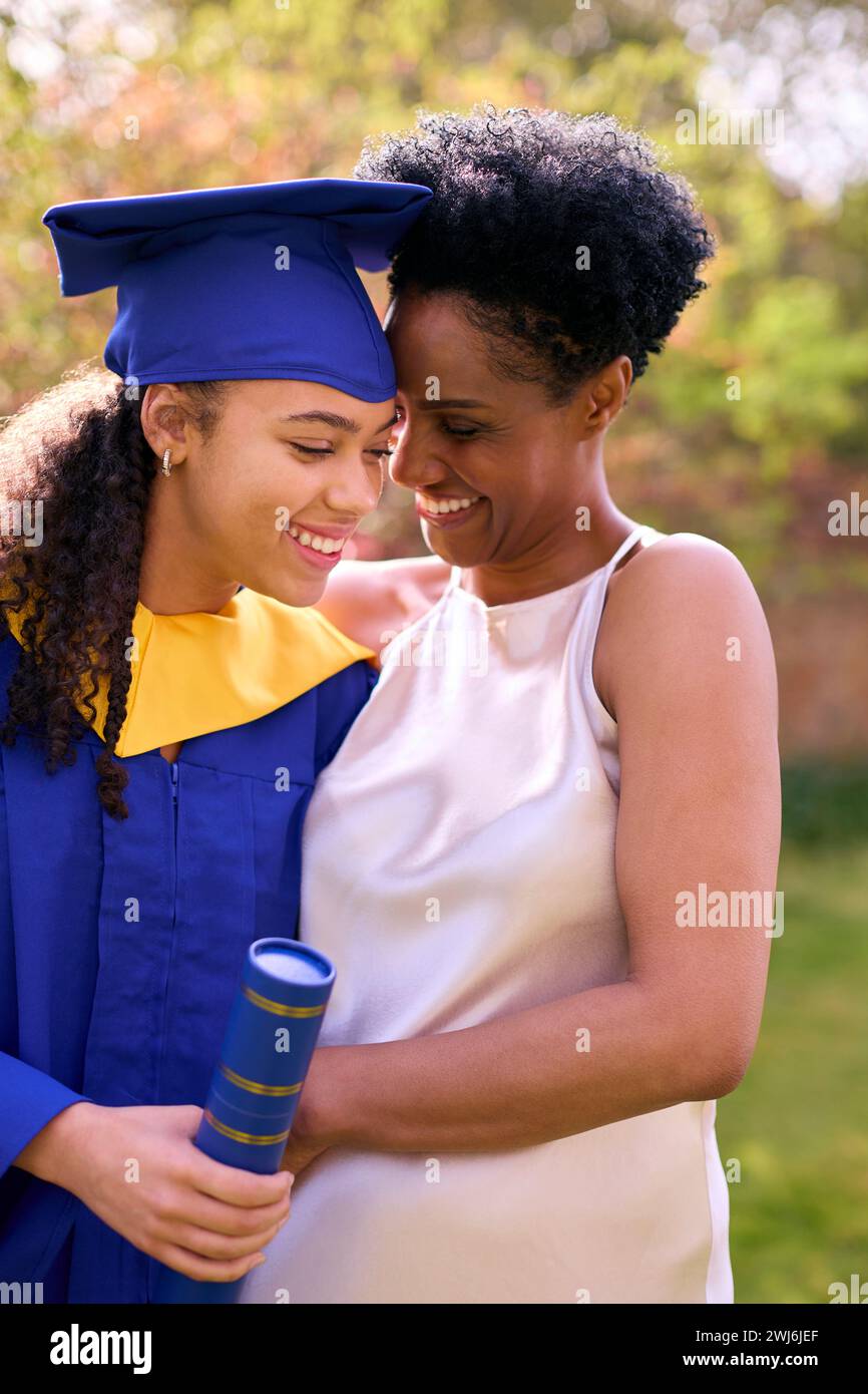 Proud Mother Celebrating With Teenage Daughter Wearing Graduation Robes ...