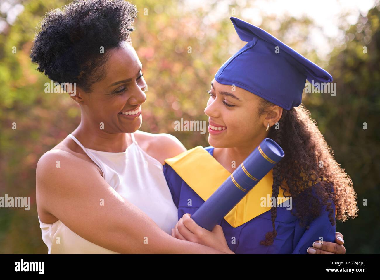 Proud Mother Celebrating With Teenage Daughter Wearing Graduation Robes ...
