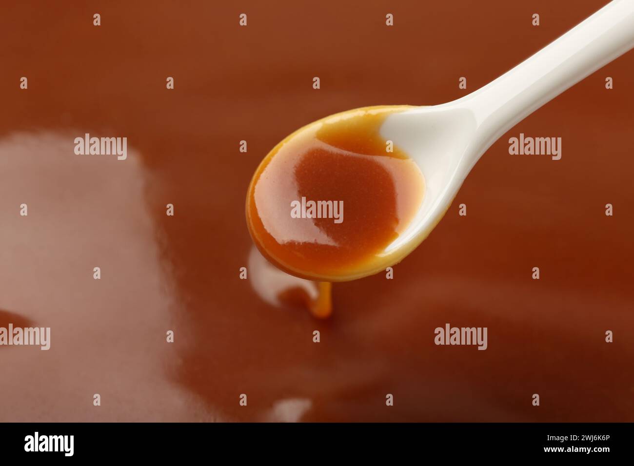 Taking tasty salted caramel with spoon, closeup. Space for text Stock ...