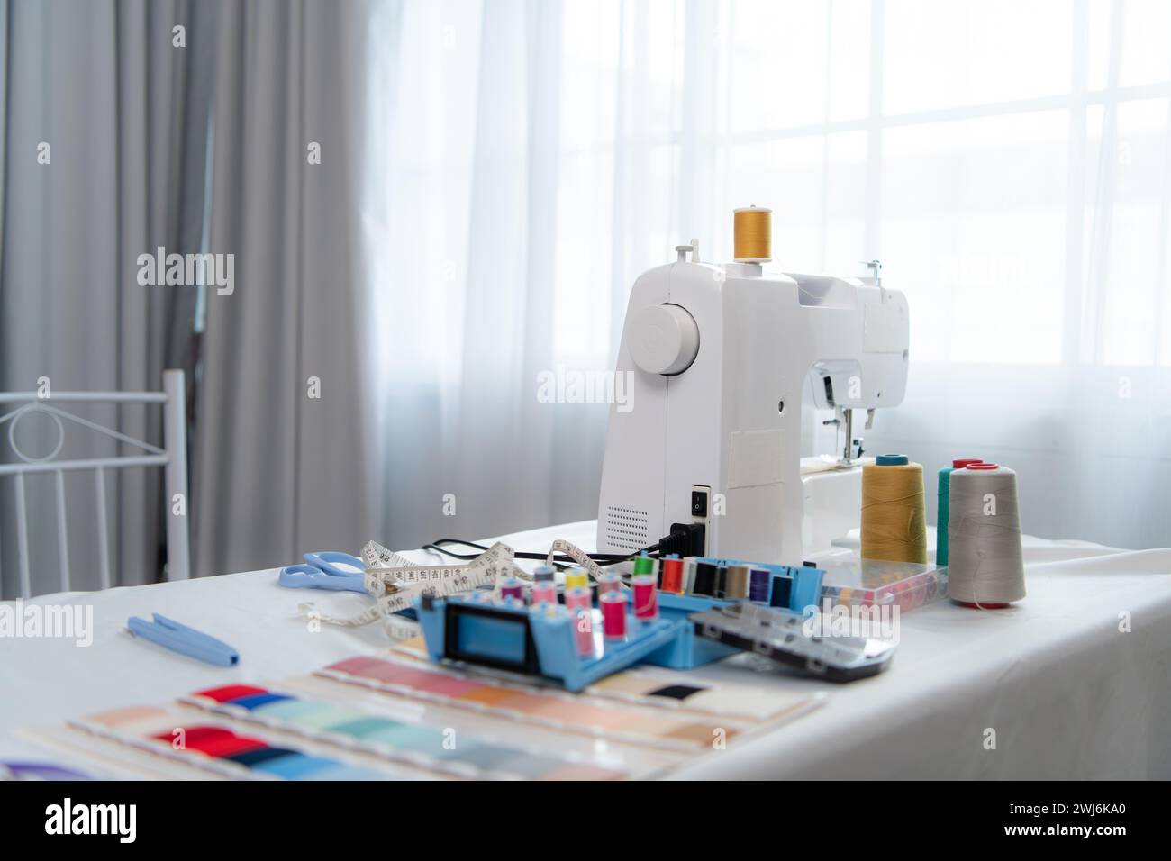 Sewing machine and accessories on the table for the work of a bridal ...
