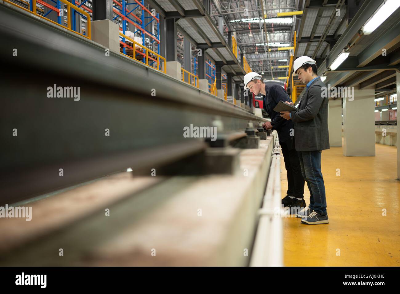Two businessmen inspect rail work to reserve equipment for use in ...