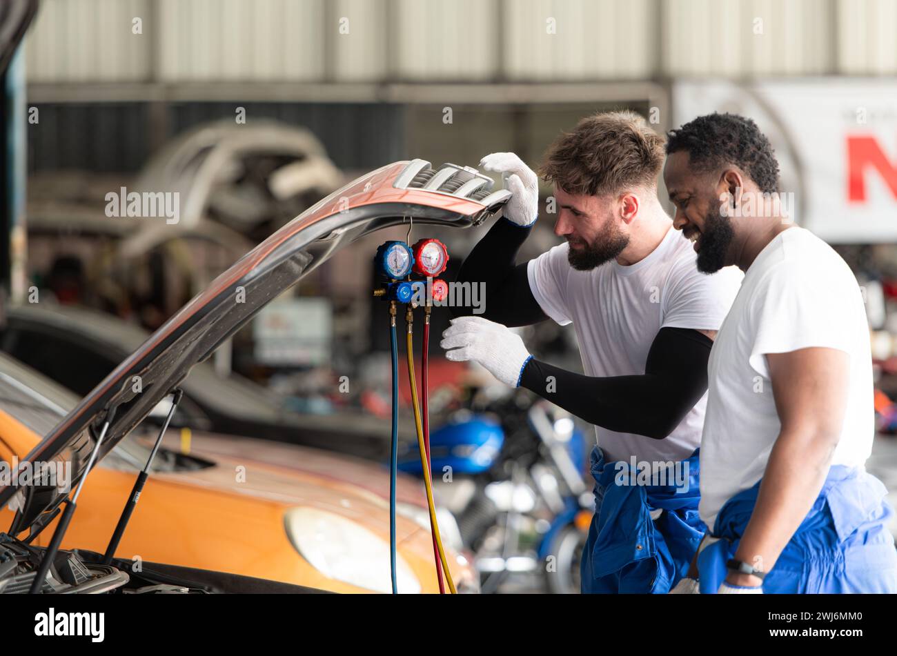 Car mechanic working in an auto repair shop, inspecting the operation of the car's air ...