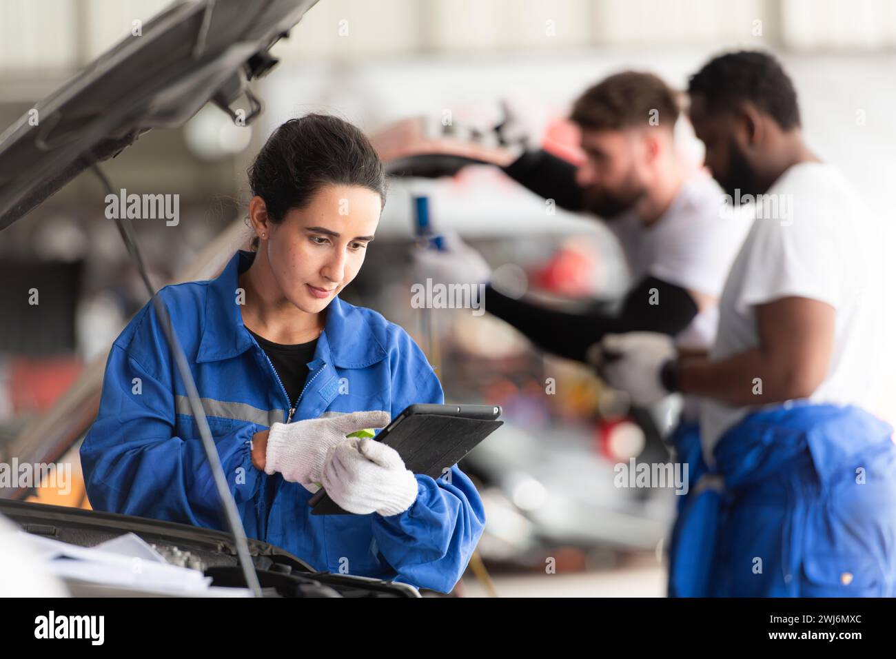 Car mechanic working in an auto repair shop, inspecting the operation of the car's air ...