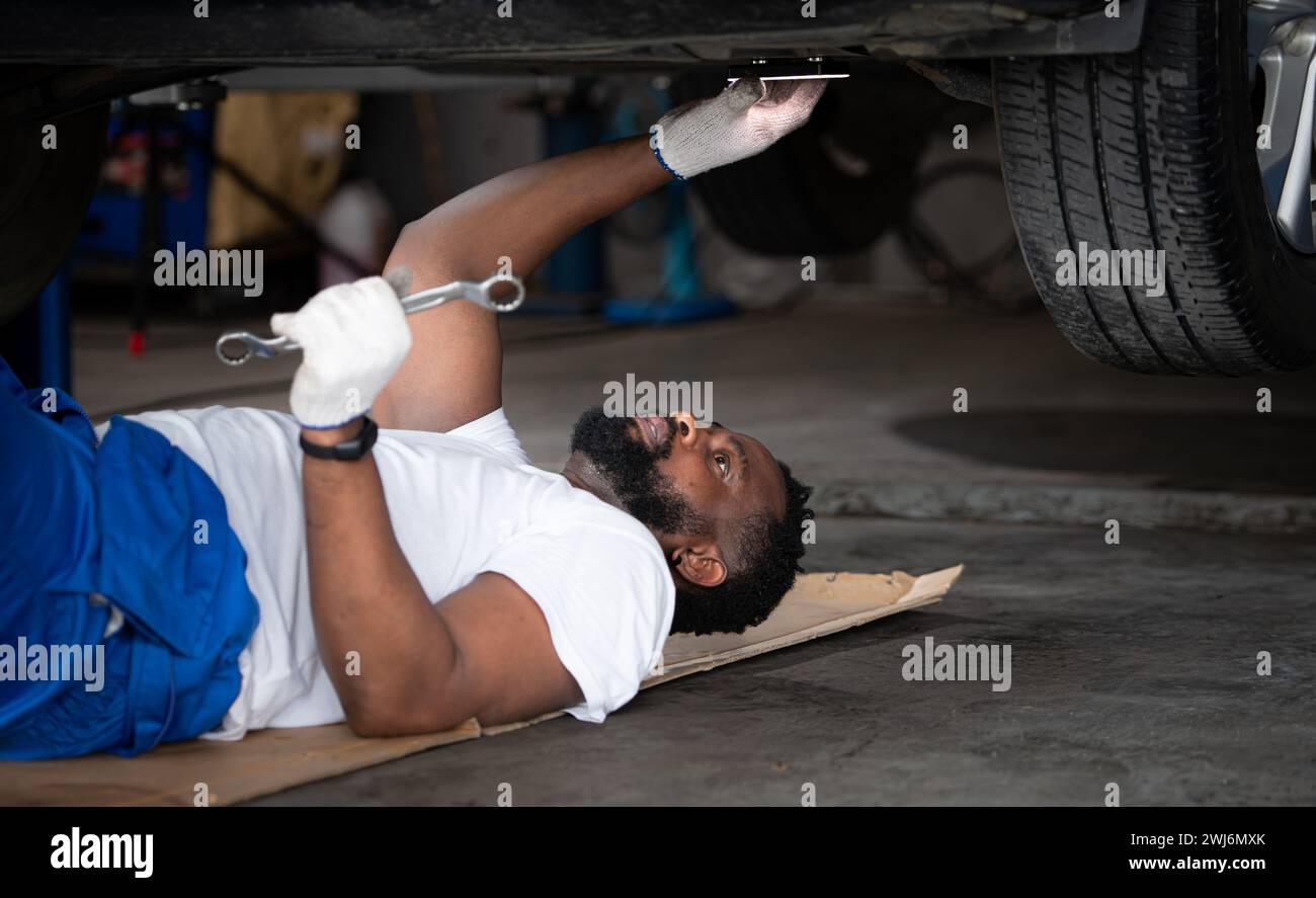 Car mechanic working in an auto repair shop, Check the operation of the ...