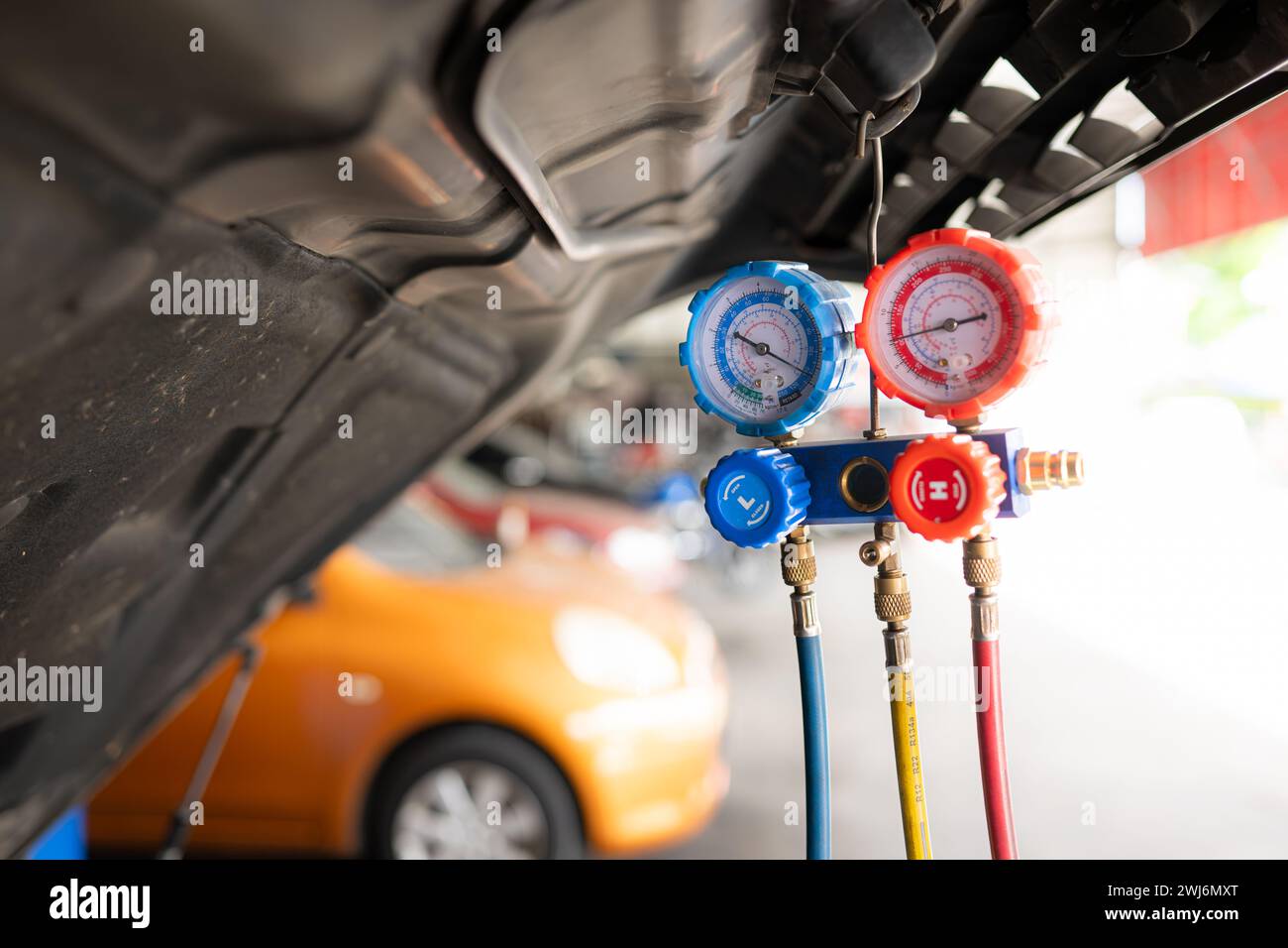 Car mechanic working in auto repair shop, inspecting the operation of ...