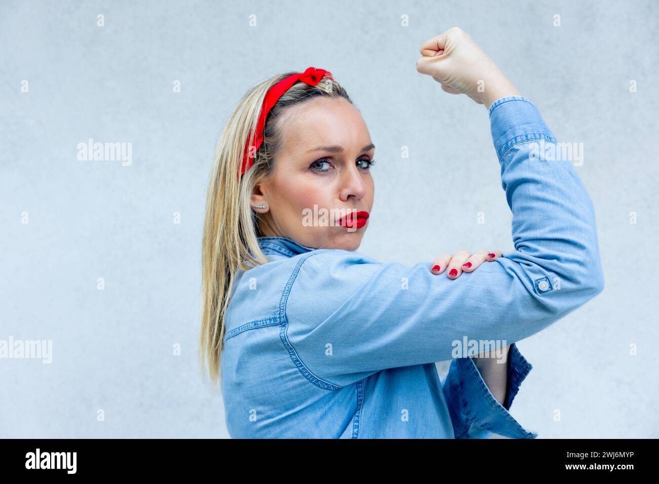 A young woman channels the iconic feminist strength, her fist raised in ...