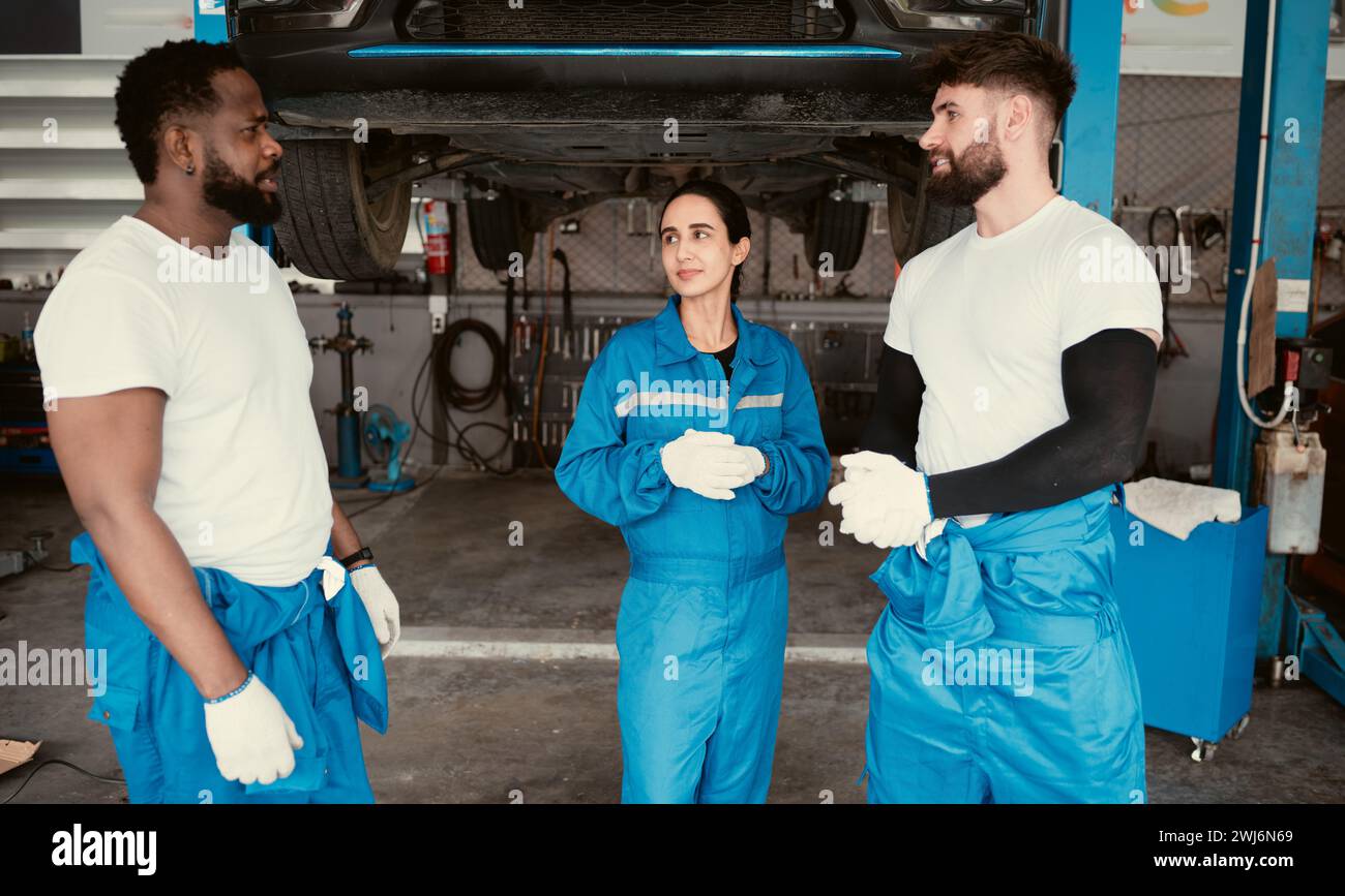 Portrait of smiling team of mechanics in auto repair shop, Talking one ...