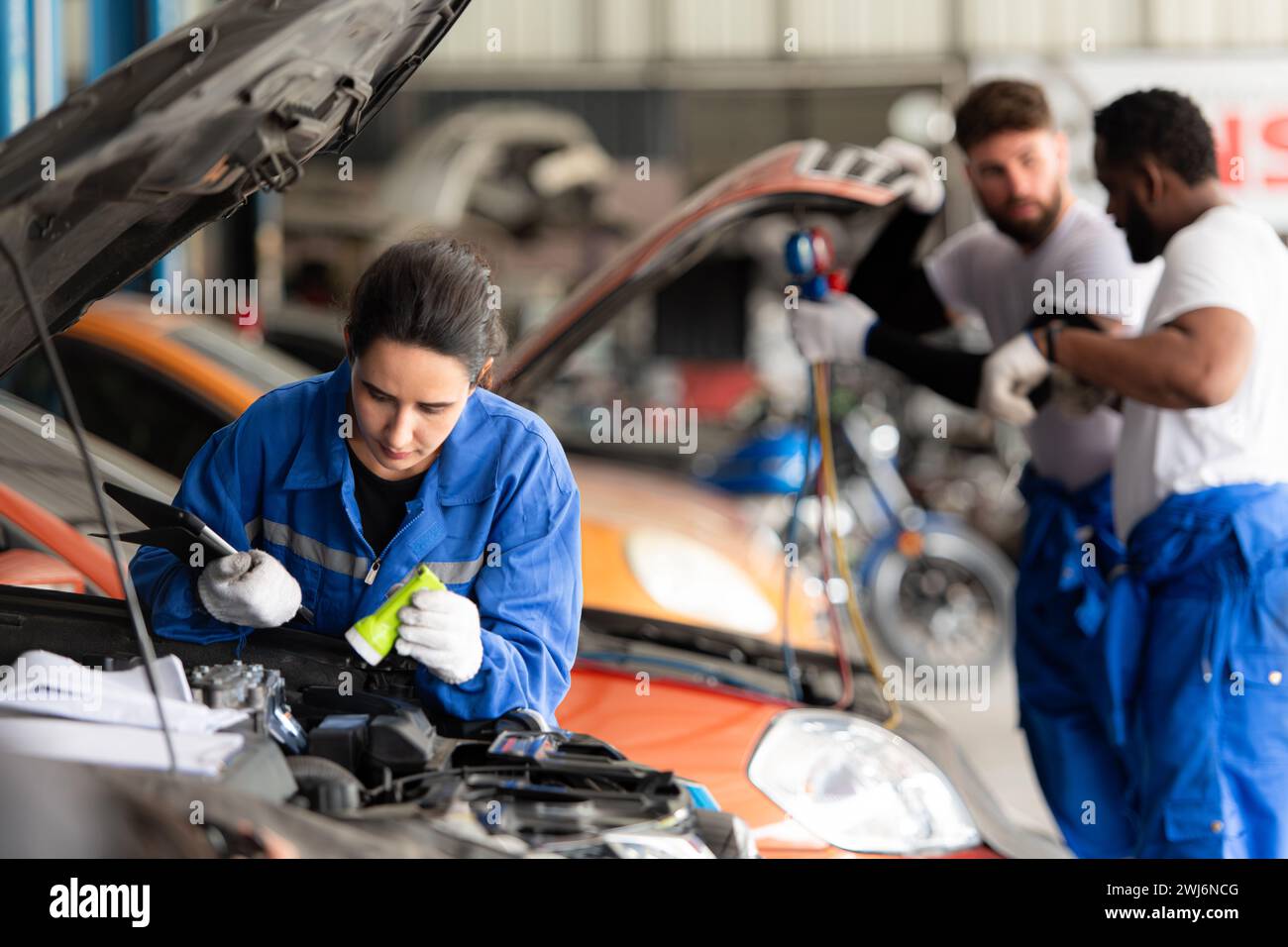 Car mechanic working in an auto repair shop, inspecting the operation ...
