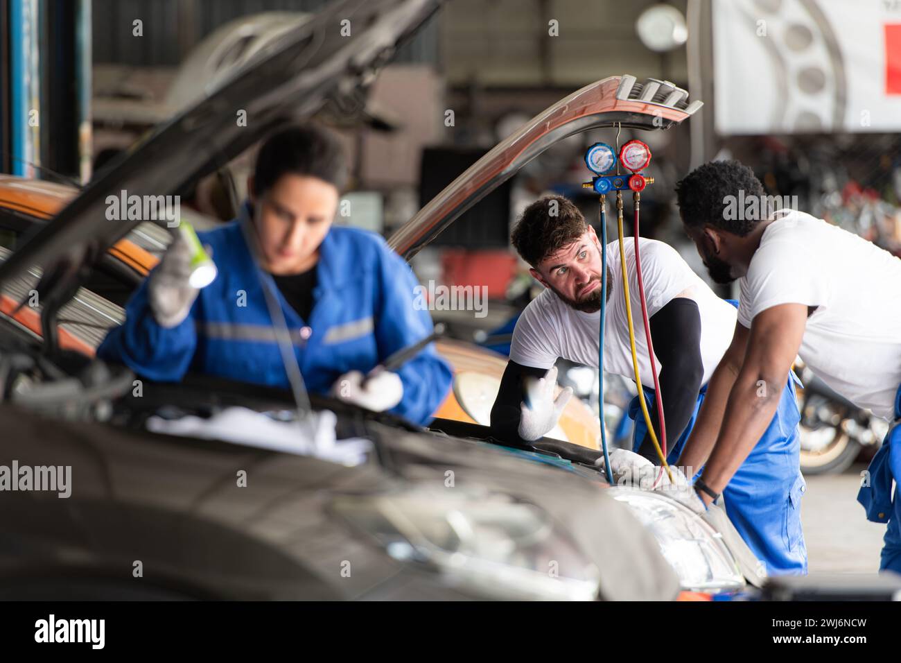 Car mechanic working in an auto repair shop, inspecting the operation of the car's air ...