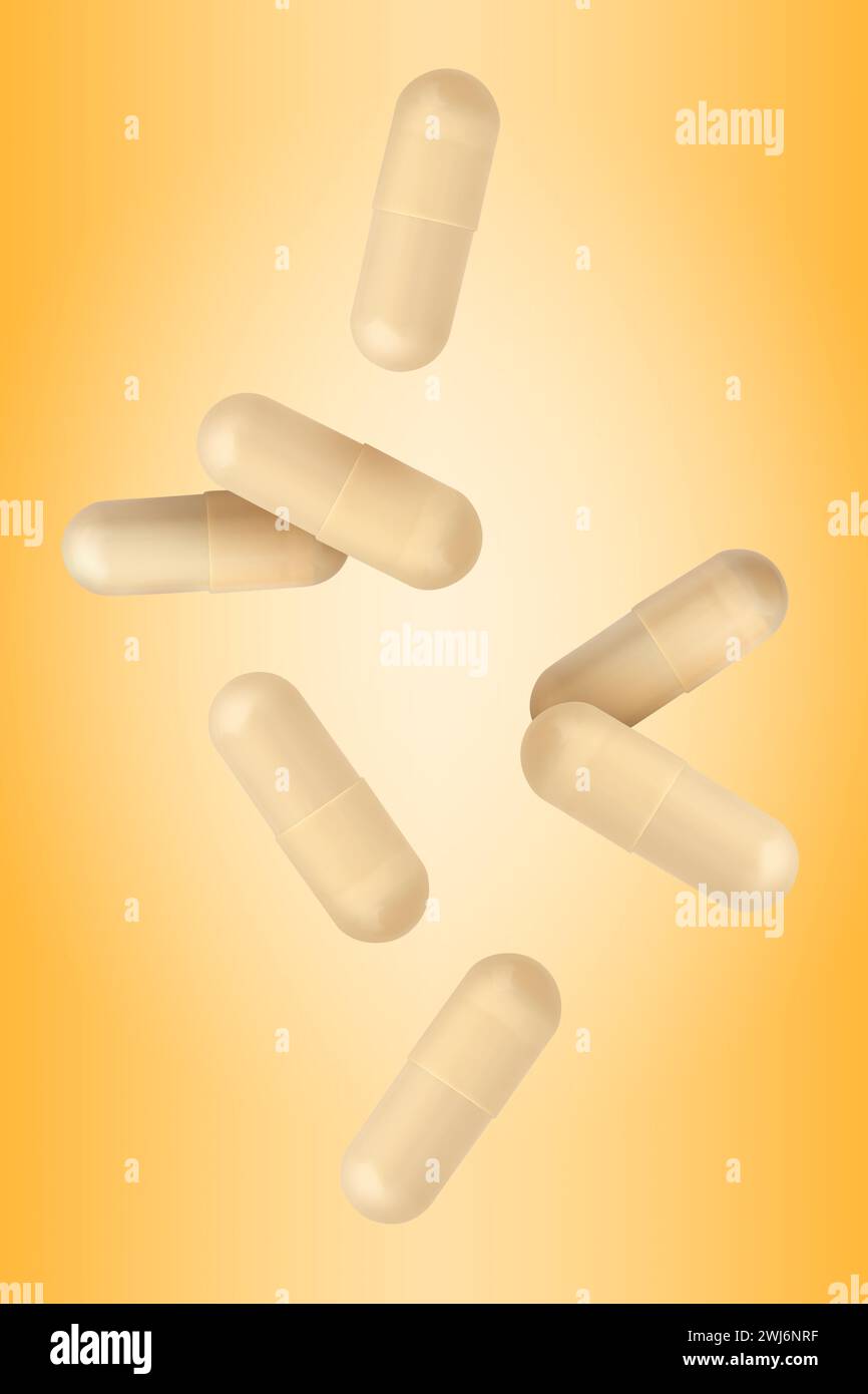 Vitamin. Capsules falling on orange gradient background Stock Photo - Alamy