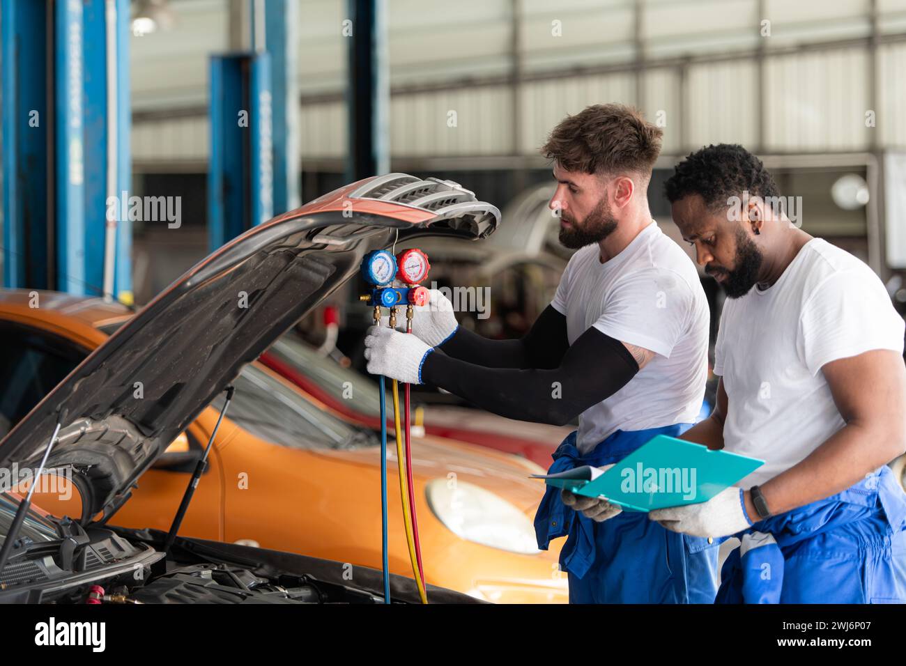 Car mechanic working in an auto repair shop, inspecting the operation of the car's air ...