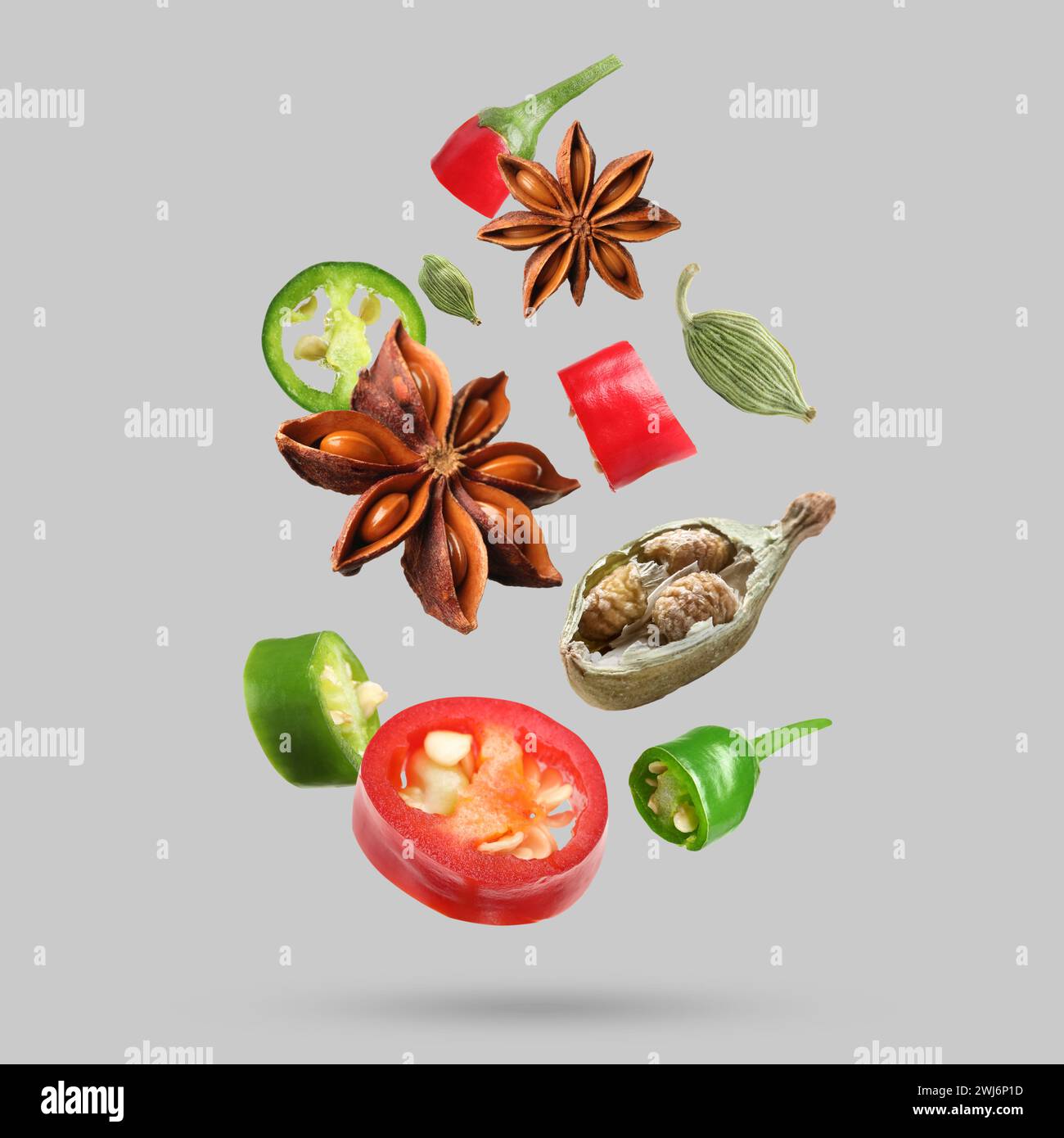 Different spices falling on light grey background Stock Photo - Alamy