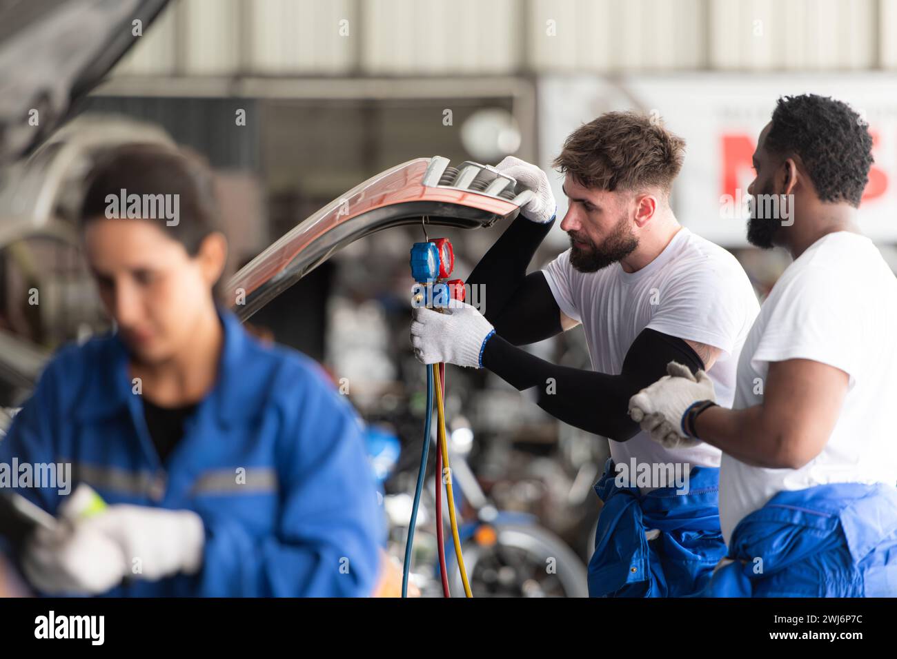 Car mechanic working in an auto repair shop, inspecting the operation of the car's air ...