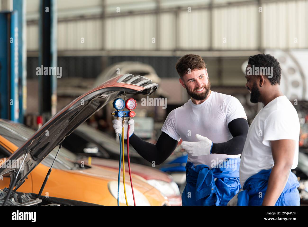 Car mechanic working in an auto repair shop, inspecting the operation of the car's air ...