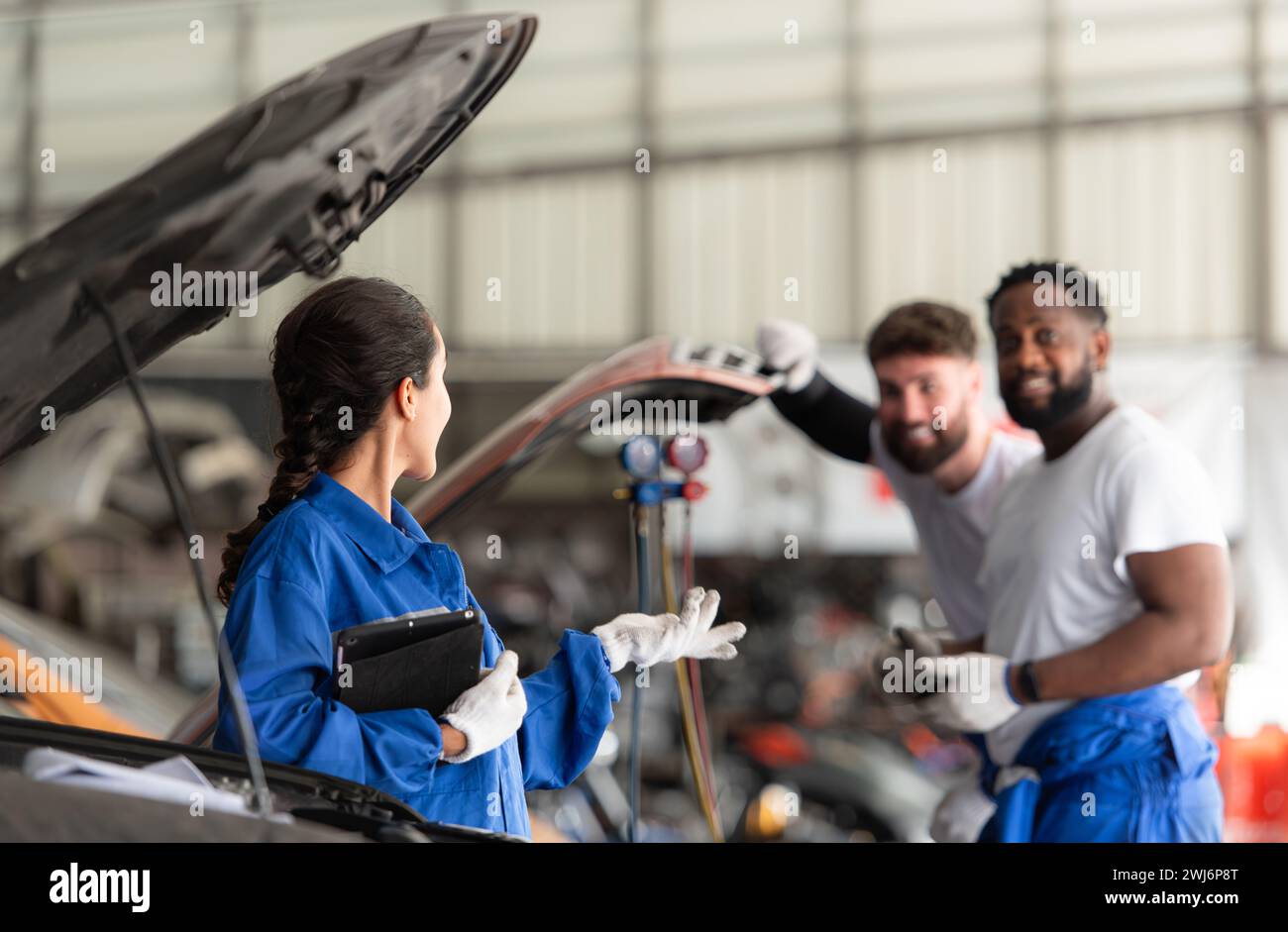 Car mechanic working in an auto repair shop, inspecting the operation of the car's air ...